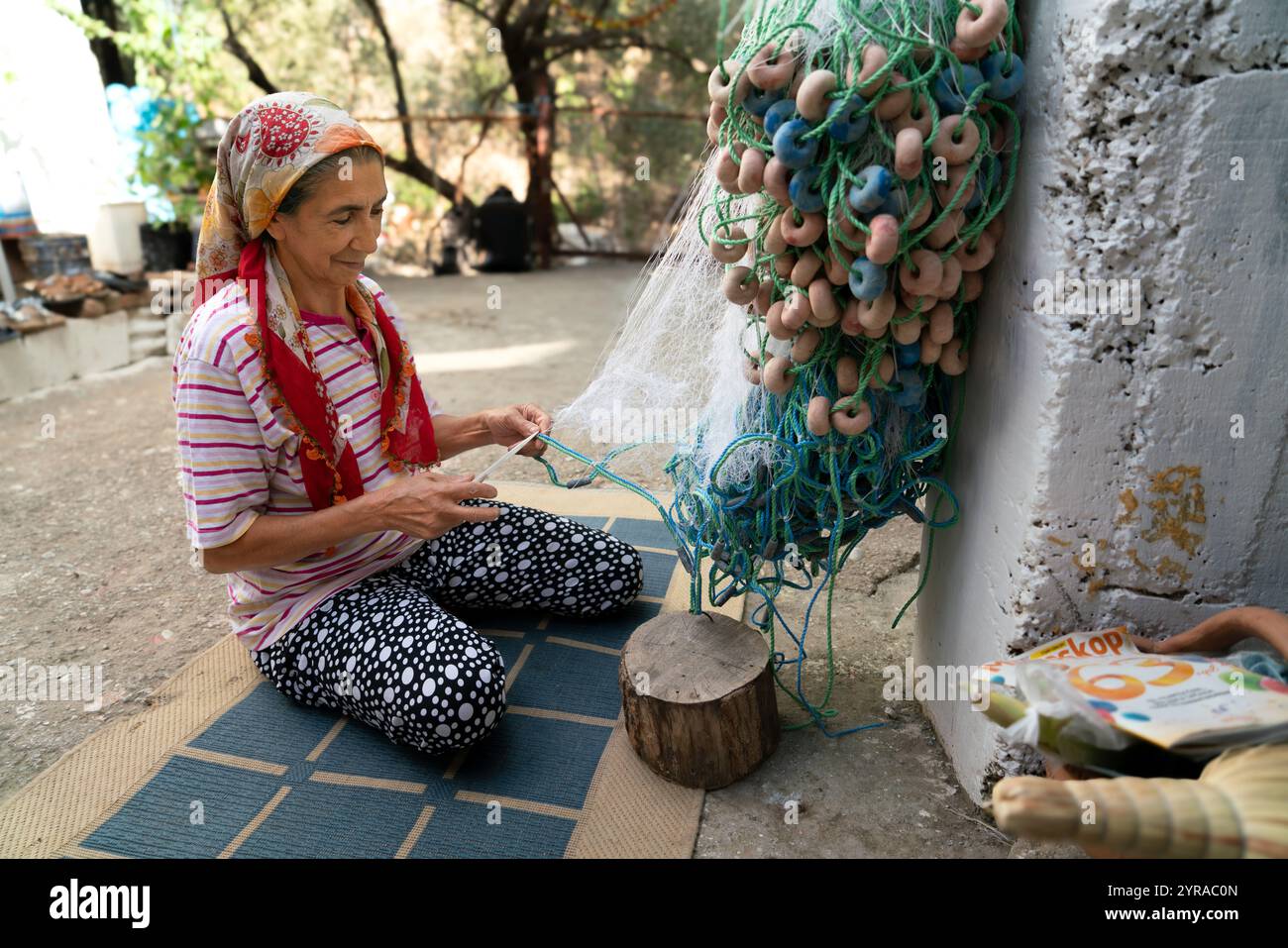 Turkey, Gulf of Gökova, Aegean Sea: elderly woman crouched on the ...