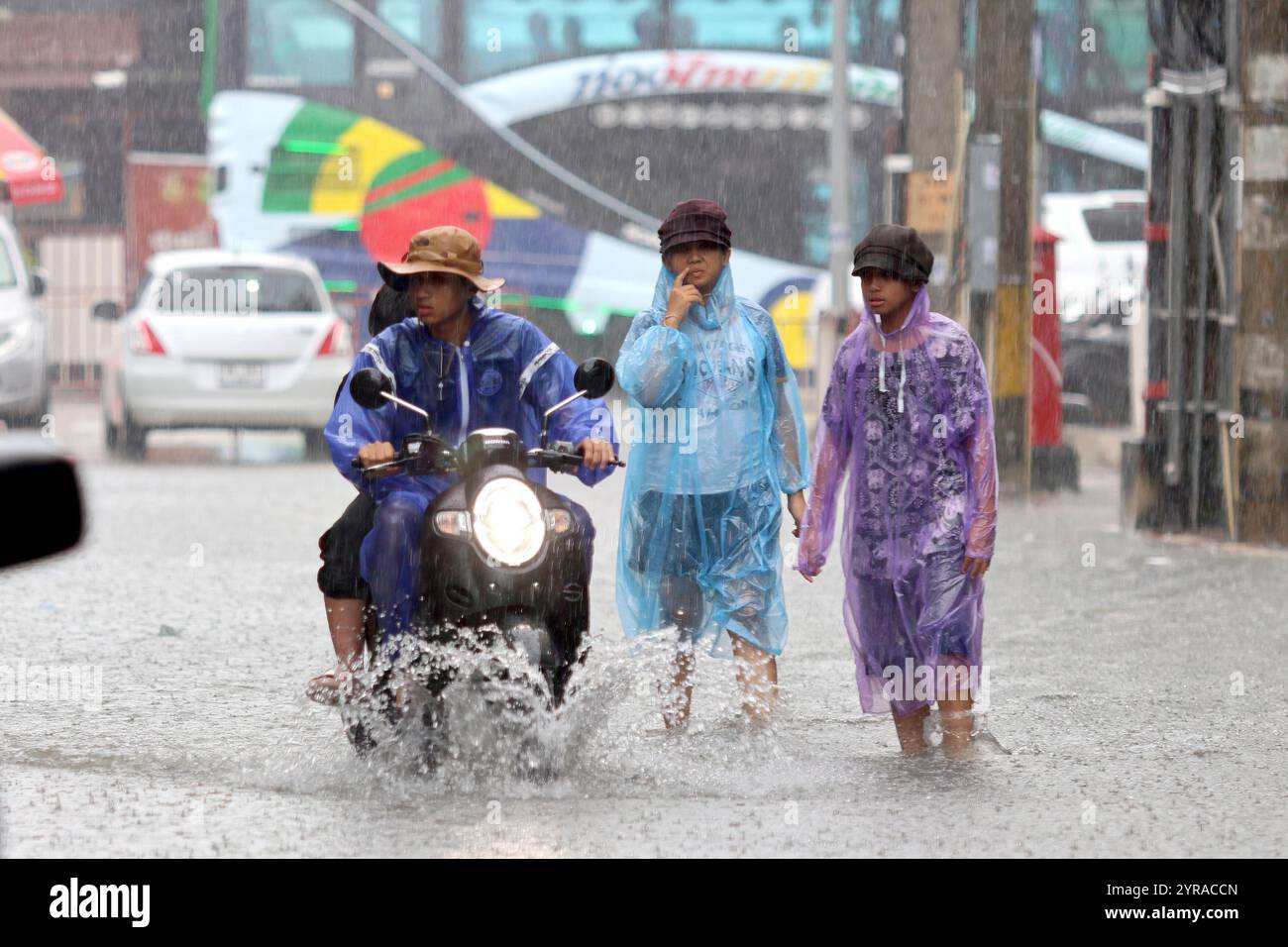 (241203) -- YALA, Dec. 3, 2024 (Xinhua) -- People walk in flood water ...