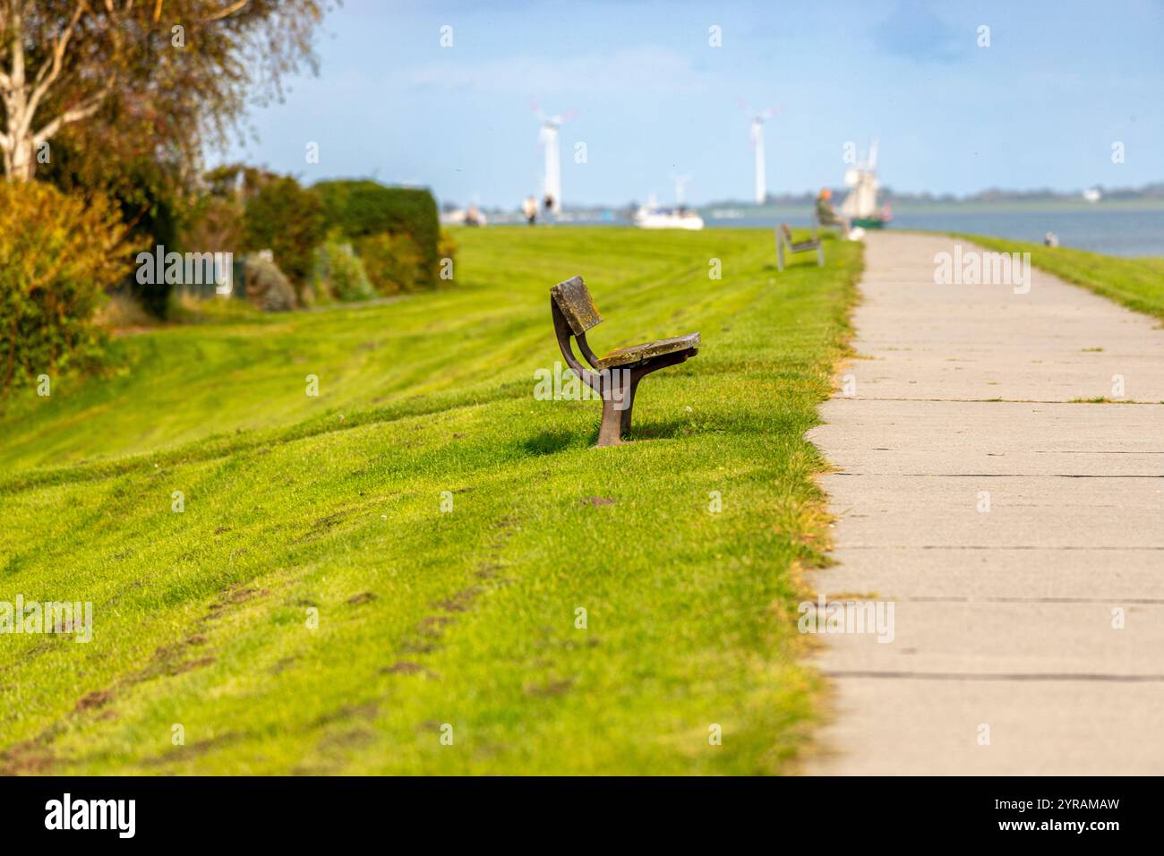 A bench on a dike with a pedestrian and bike path. High quality photo ...