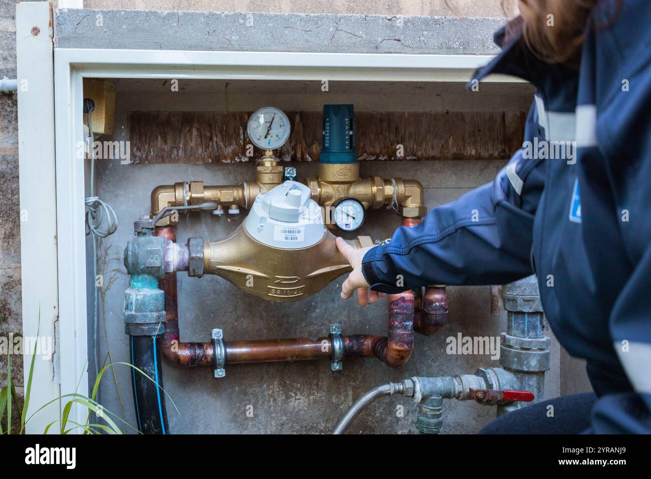 Water management. Water manager checking a water meter *** Local ...