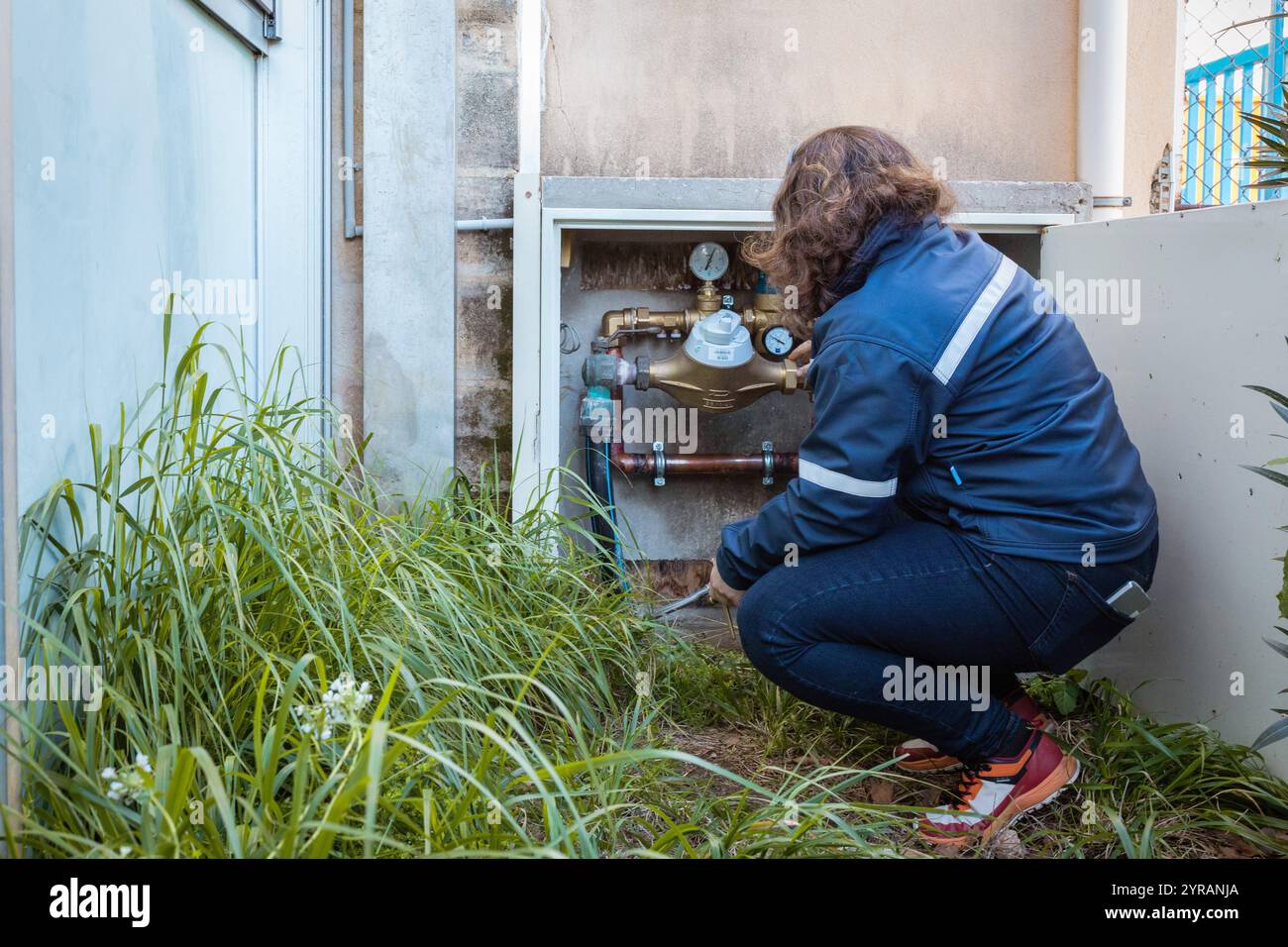 Water management. Water manager checking a water meter *** Local ...