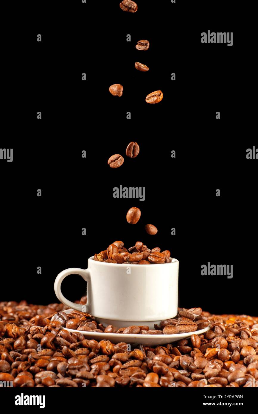 Vertical photo showing a row of coffee beans falling on a white coffee ...