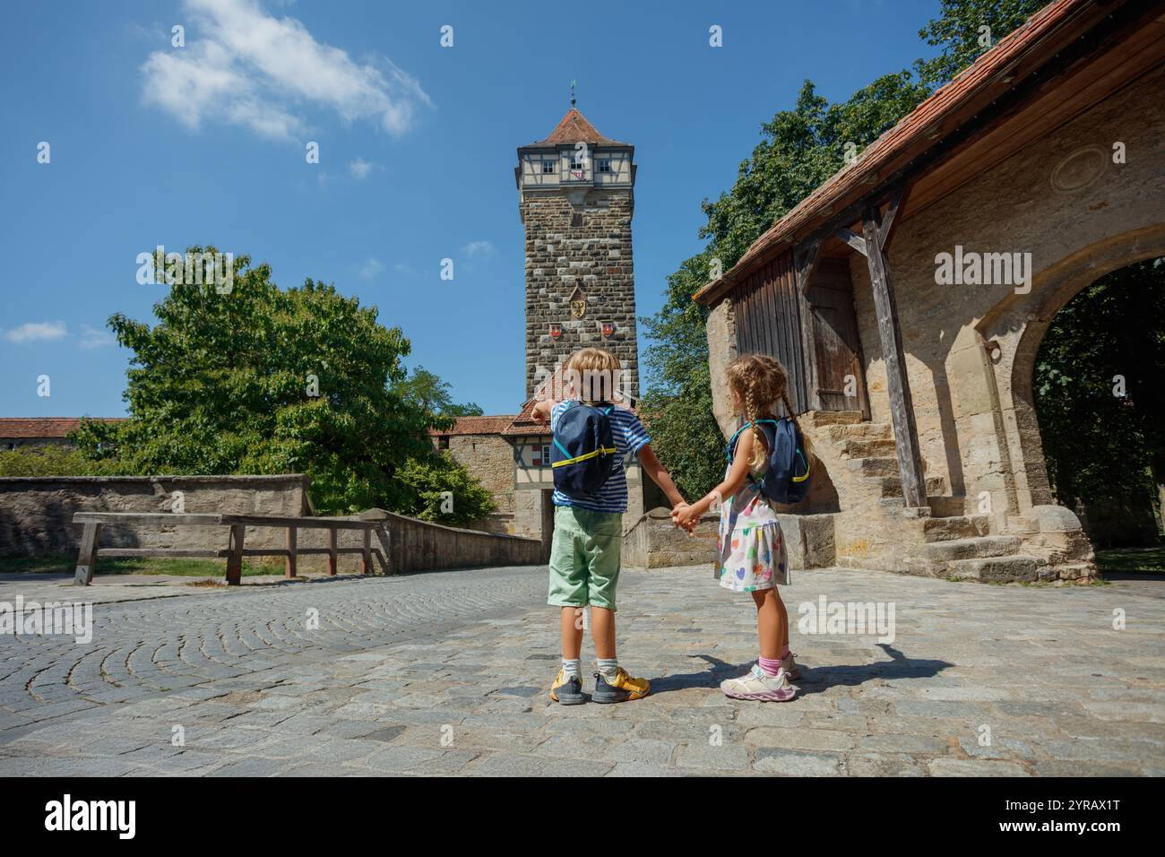Two kids holding hands, exploring an old stone tower Stock Photo - Alamy
