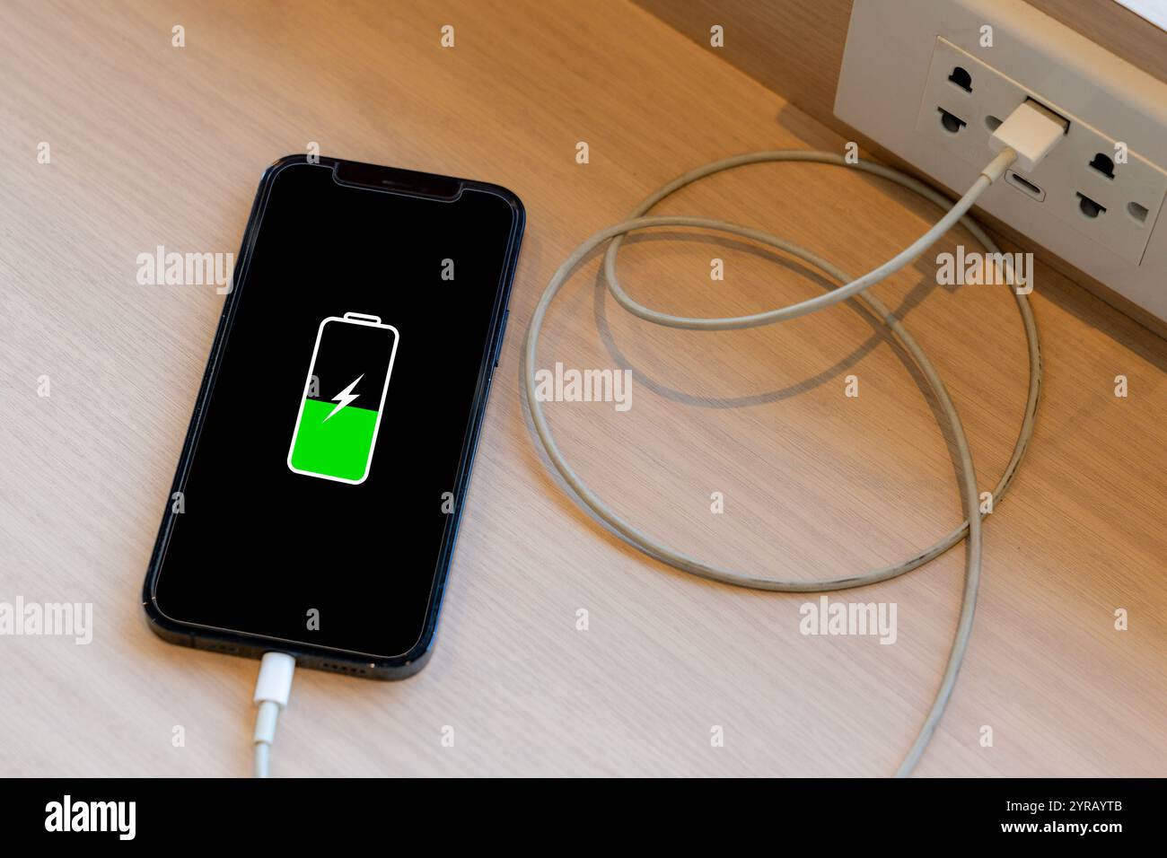 hand holding smart phone connecting with electric power for recharge ...