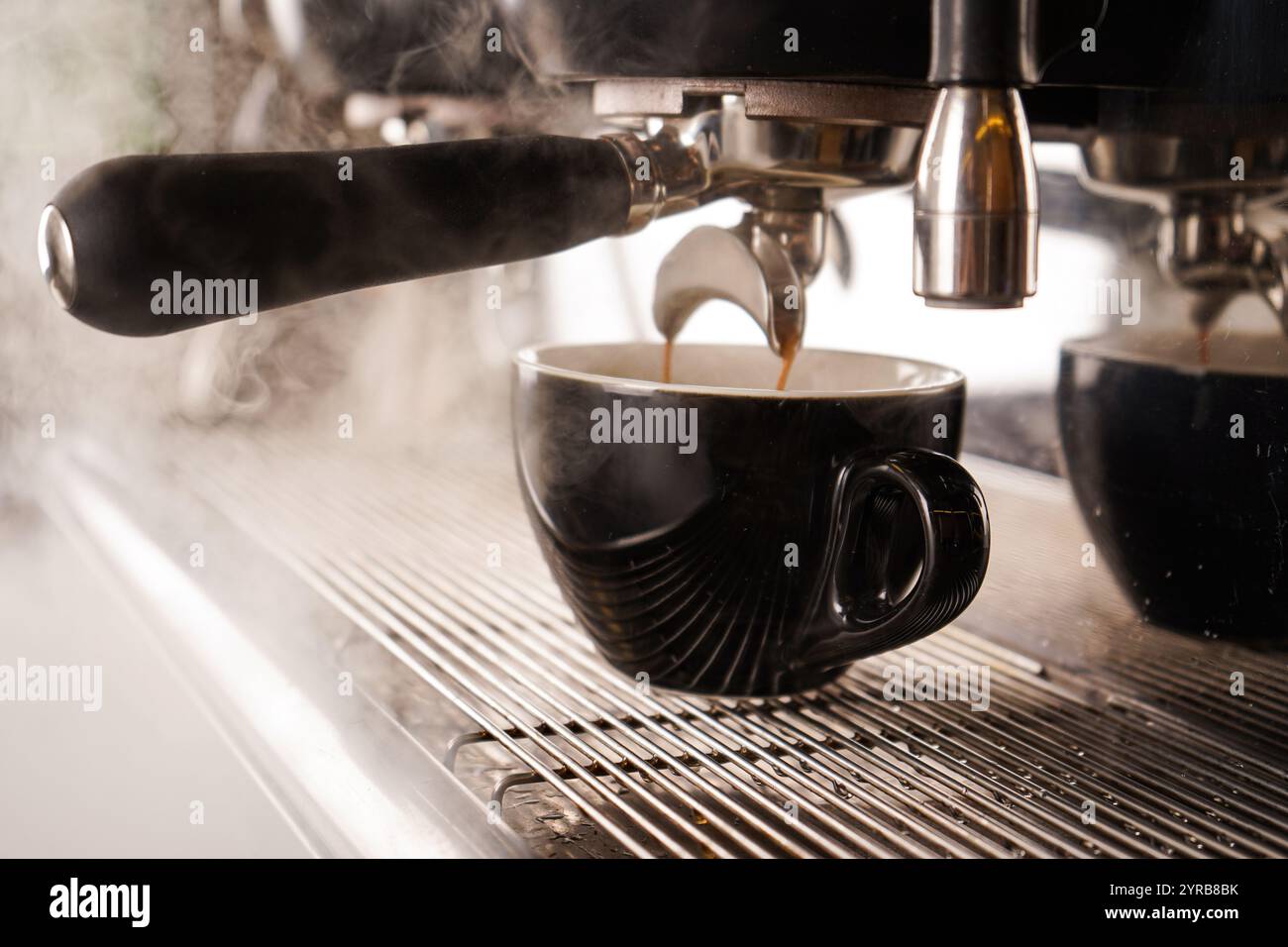 Close-up of Americano pouring from the coffee machine into a cup ...