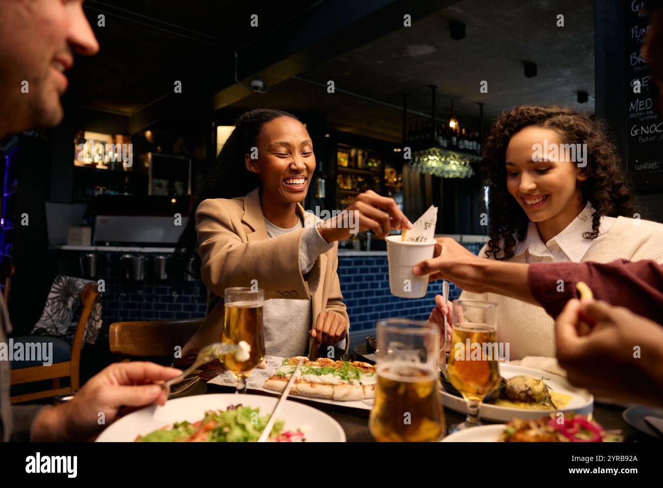 A African colleague sharing his food with his colleague Stock Photo - Alamy