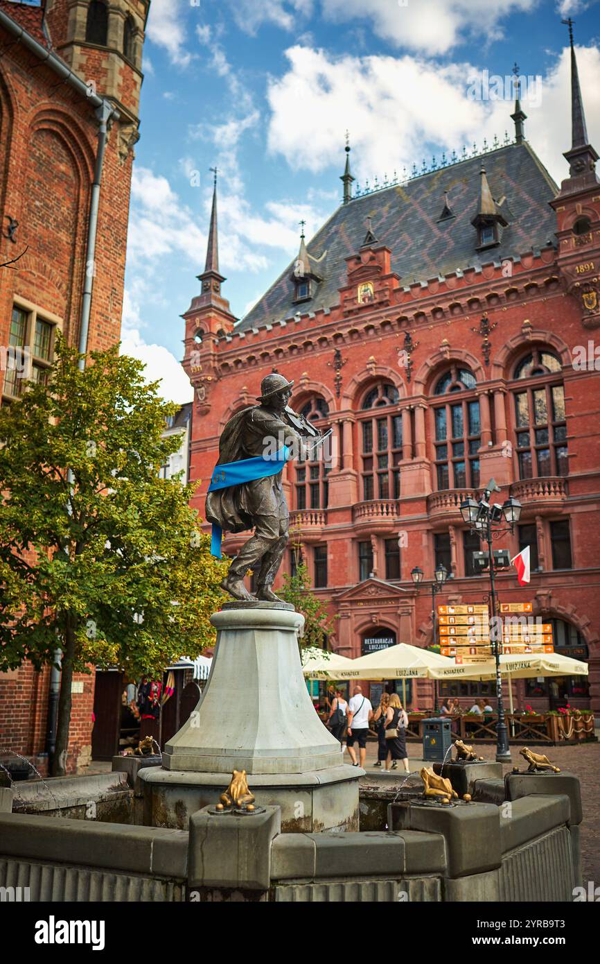 A bronze statue in Torun of a musician stands in a square, adorned with ...