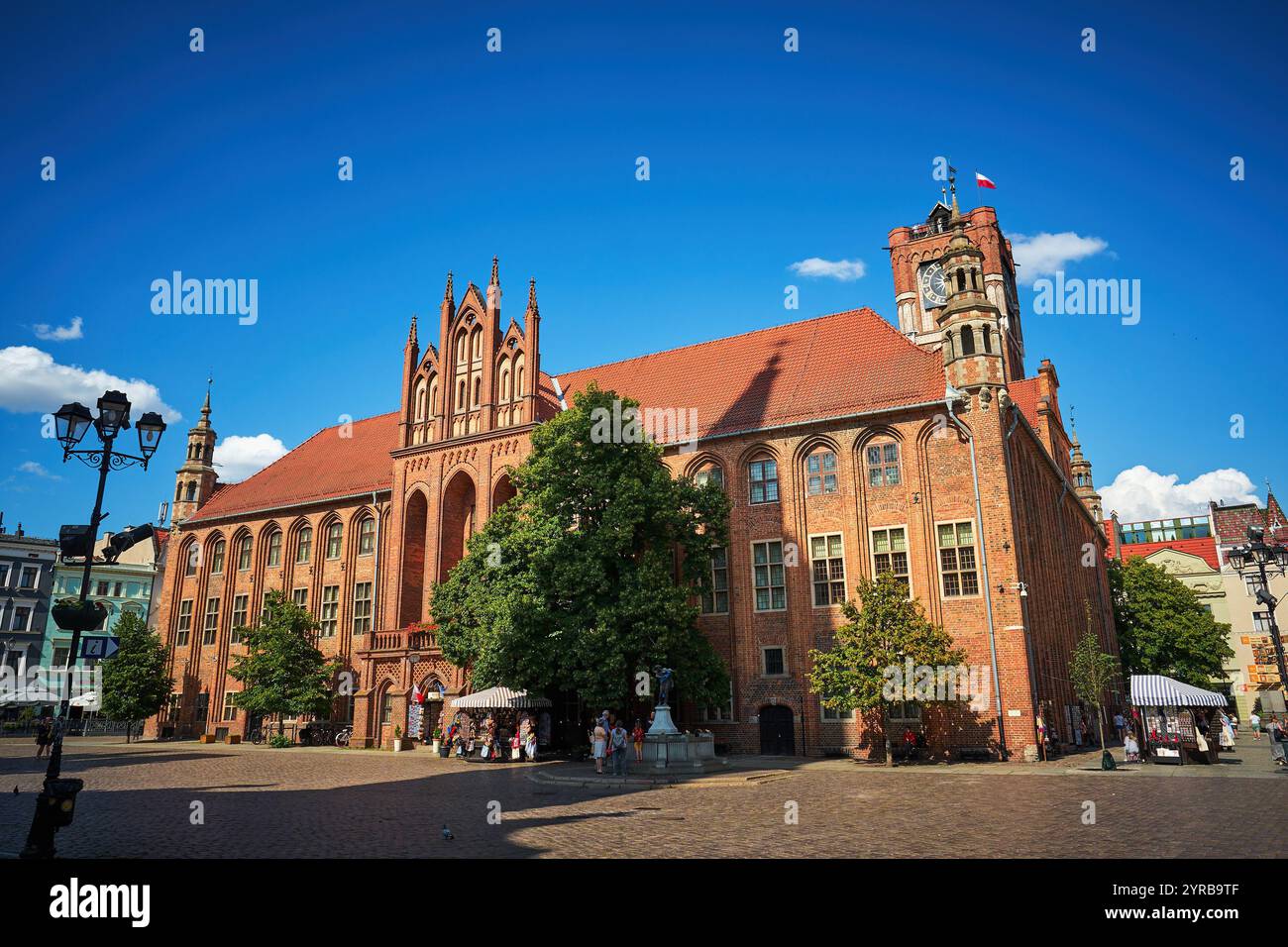 A stunning view of a historic brick building in Torun with a tall clock ...