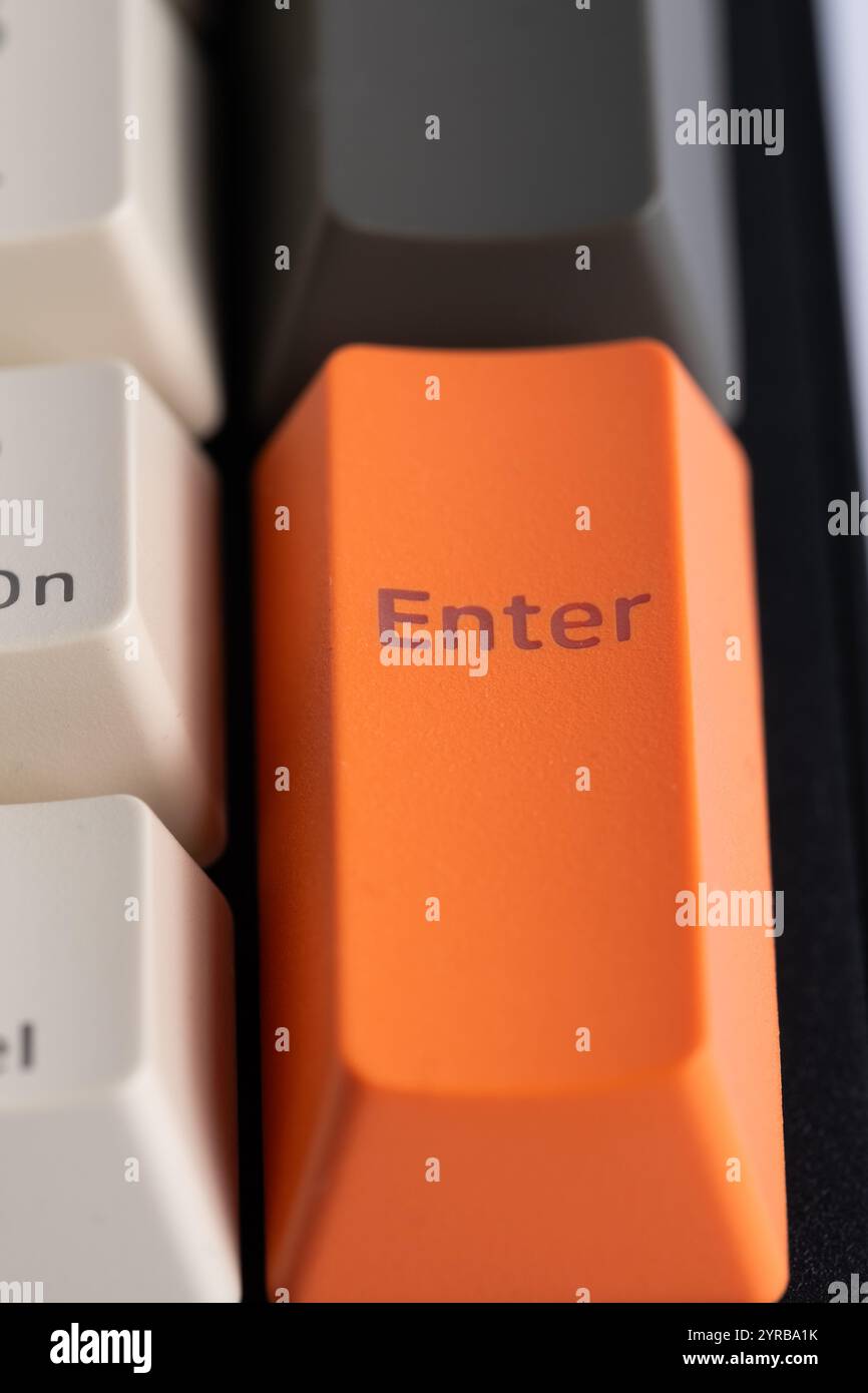 Orange Enter key on black computer keyboard Stock Photo - Alamy