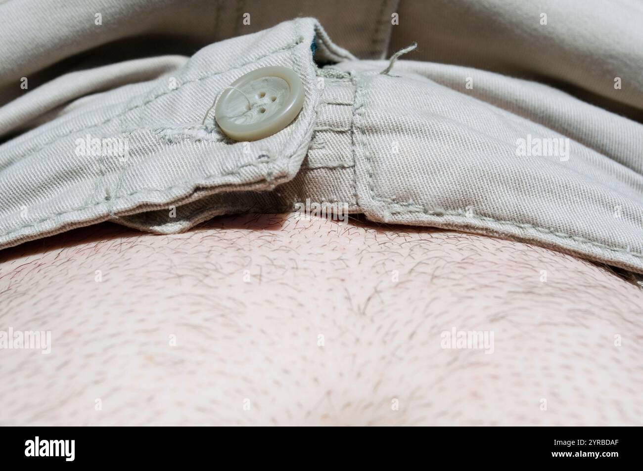Trousers button and male belly Stock Photo - Alamy