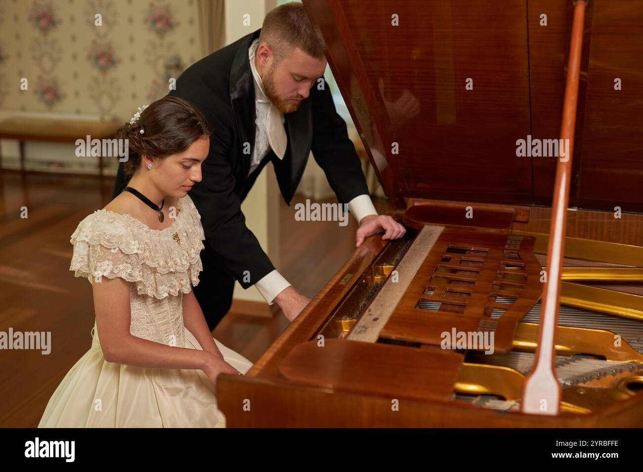 Side view portrait of classic young gentleman playing piano with lady ...