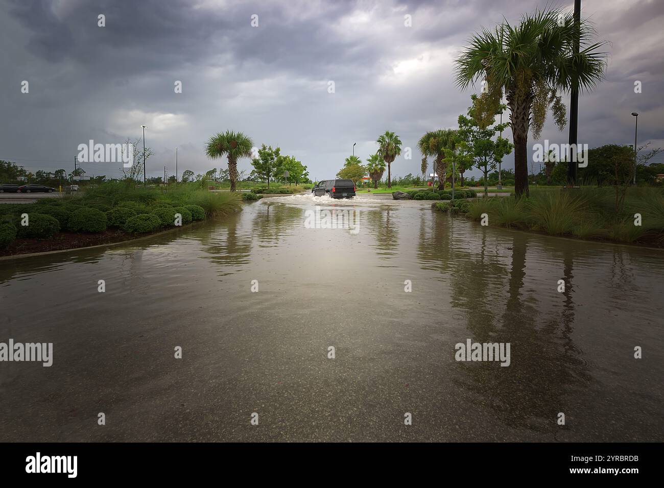 vehicle driving in parking lot submerged under heavy rain, with water ...