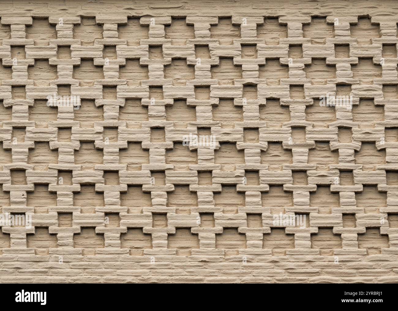 Tiled grid pattern in rough beige brickwork on exterior wall of ...