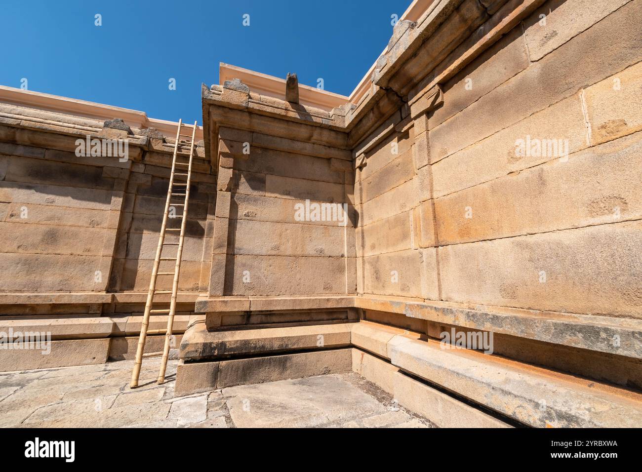 Stone architecture with a wooden ladder at Shravanabelagola, signaling ...