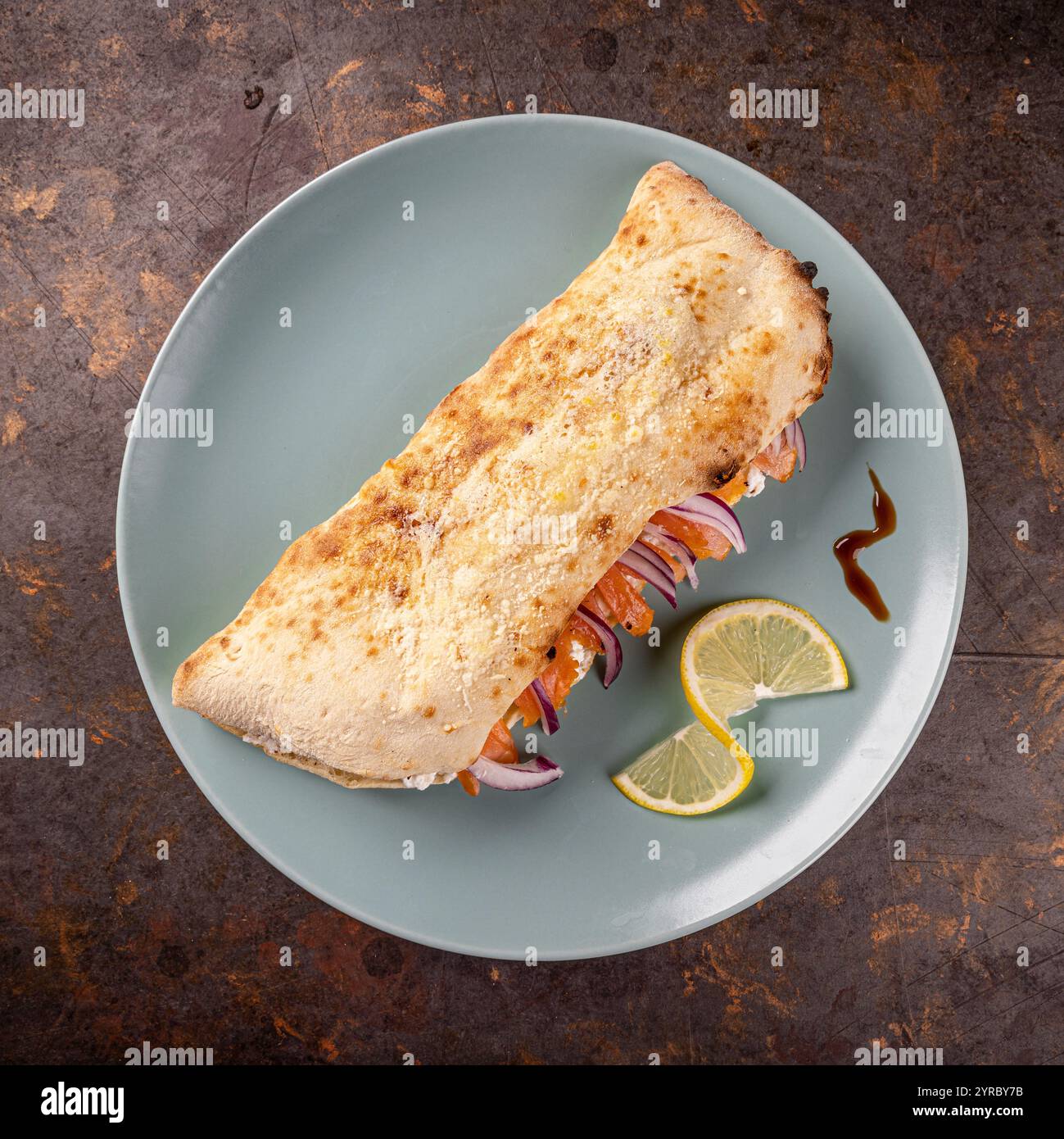 Closed calzone pizza with smoked salmon, cream cheese, red onions and ...