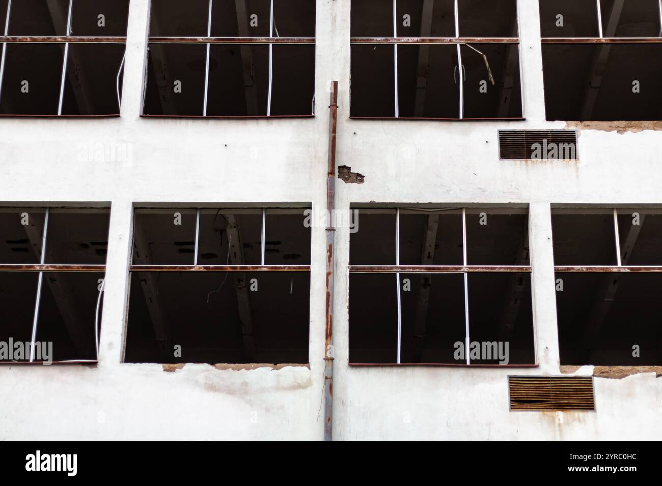 A close-up view of an abandoned building facade with rusted window ...