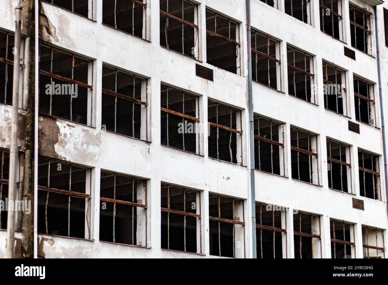 An abandoned factory building with broken windows and deteriorating ...