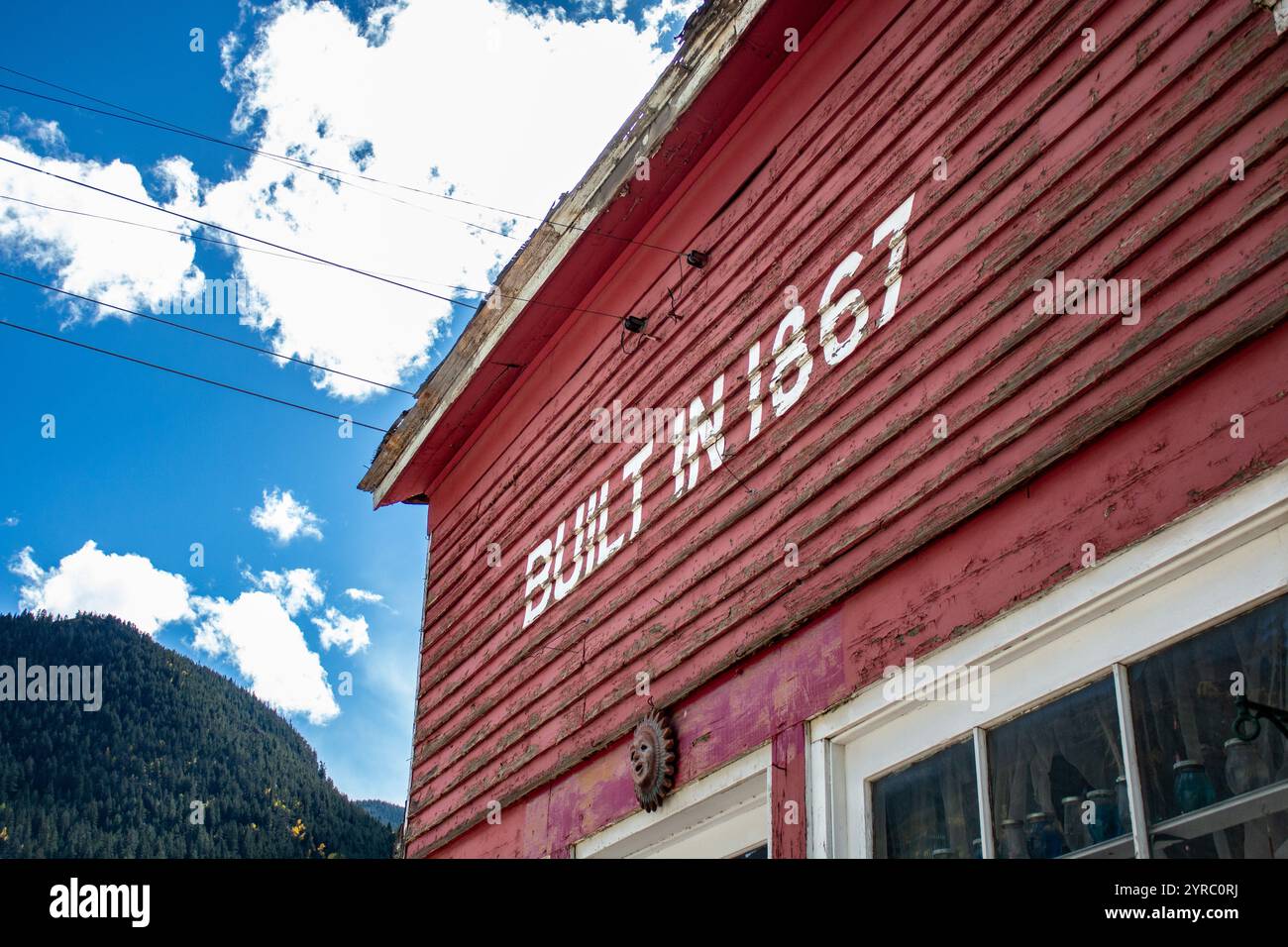 Historic red wooden building marked with “Built in 1867,” set against a ...