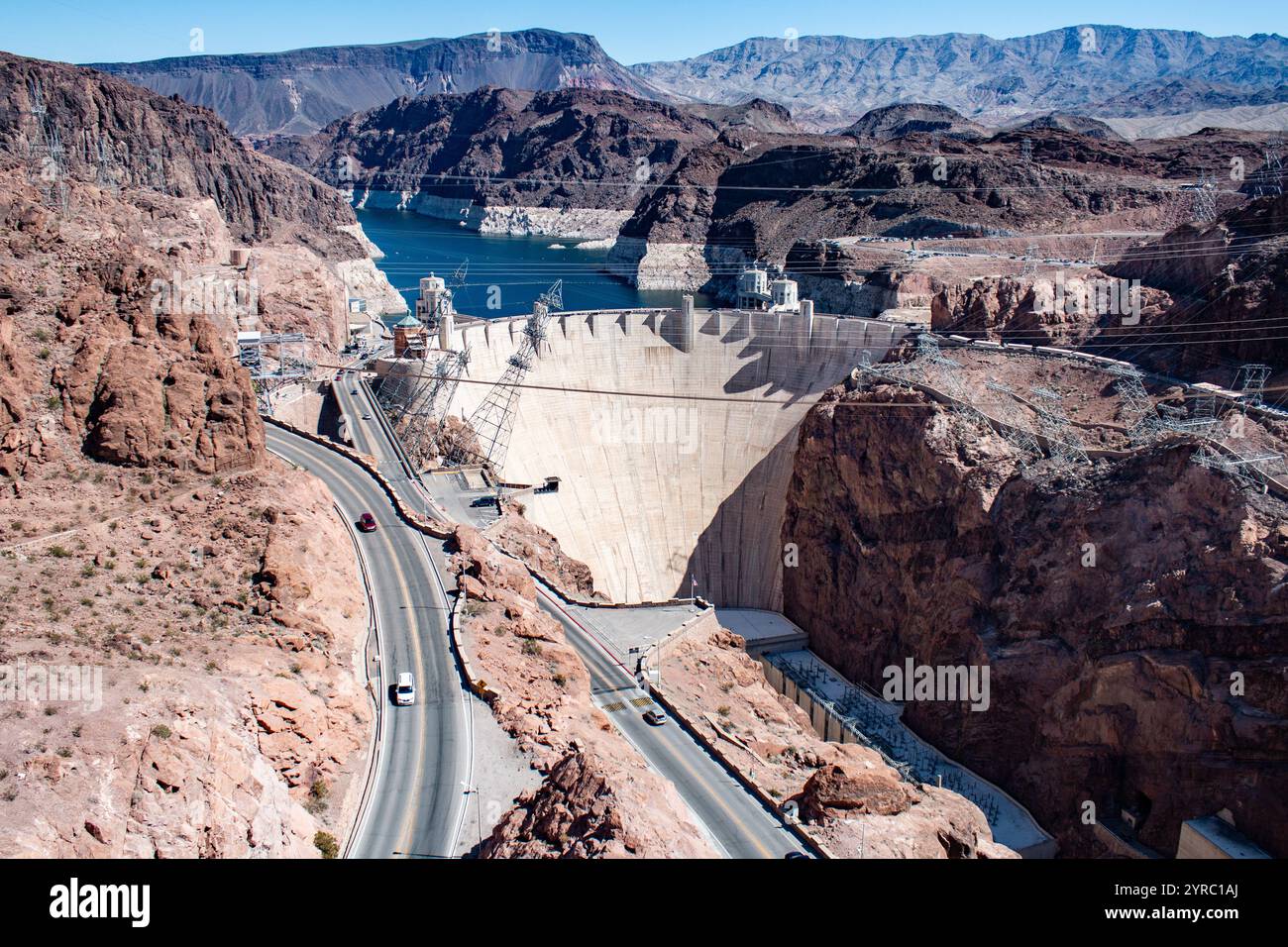 Aerial view of Hoover Dam with winding canyon road and Lake Mead in the ...