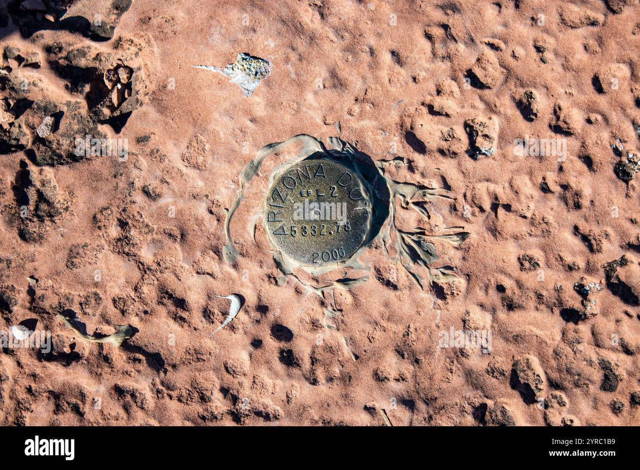 A survey marker embedded in red desert rock, showing precise elevation ...
