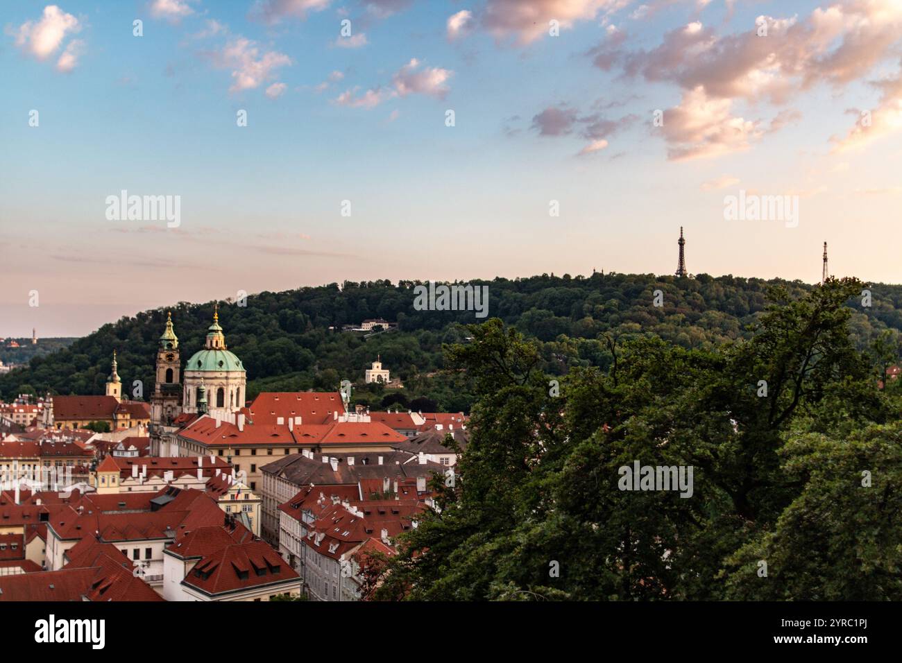 A serene sunset in Prague highlighting red rooftops, St. Nicholas ...
