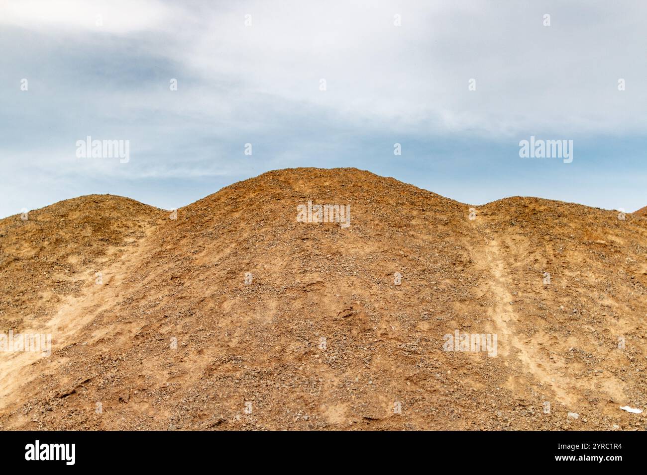 Gentle sand mounds resembling dunes, formed at a quarry site ...