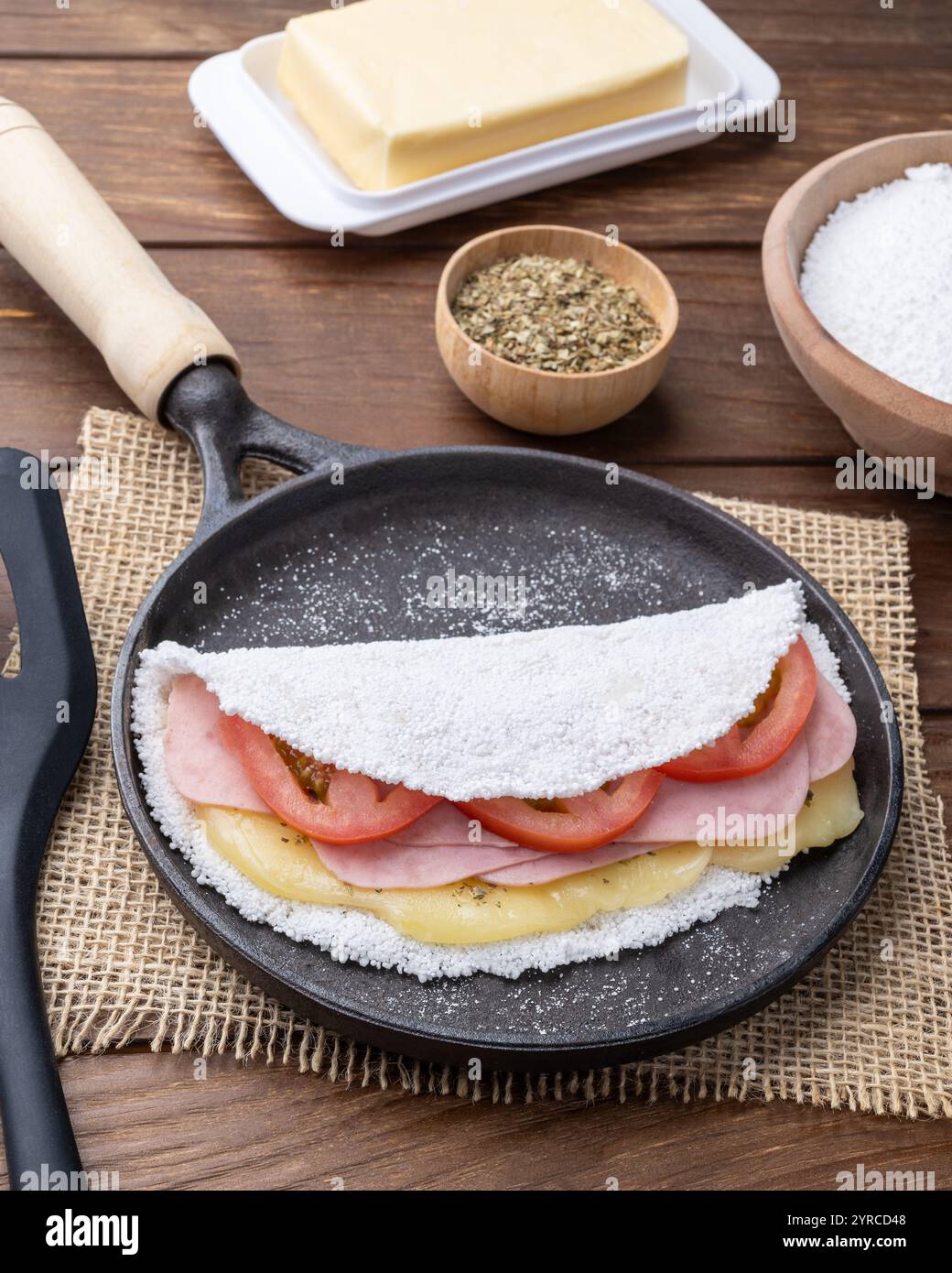 Traditional brazilian cheese, ham and tomato stuffed tapioca on a pan ...