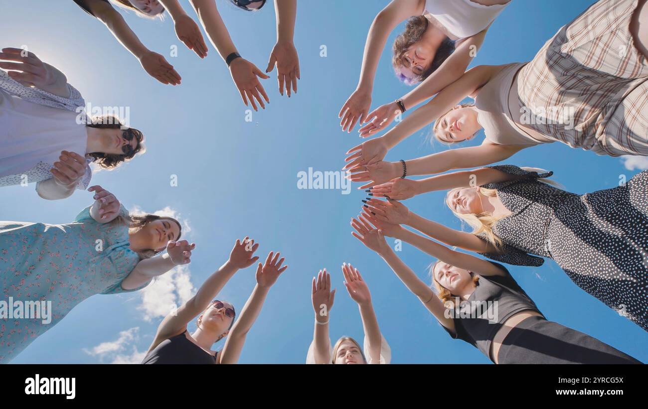 Group of friends is standing in a circle joining their hands together outdoors Stock Photo - Alamy
