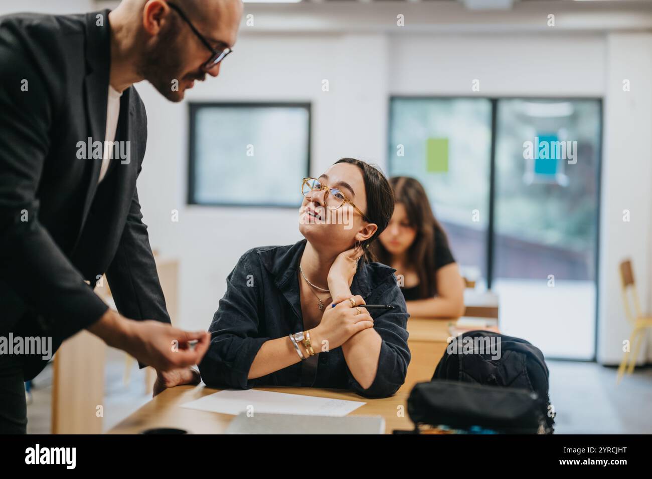 Teacher assisting students with schoolwork in a classroom setting Stock ...