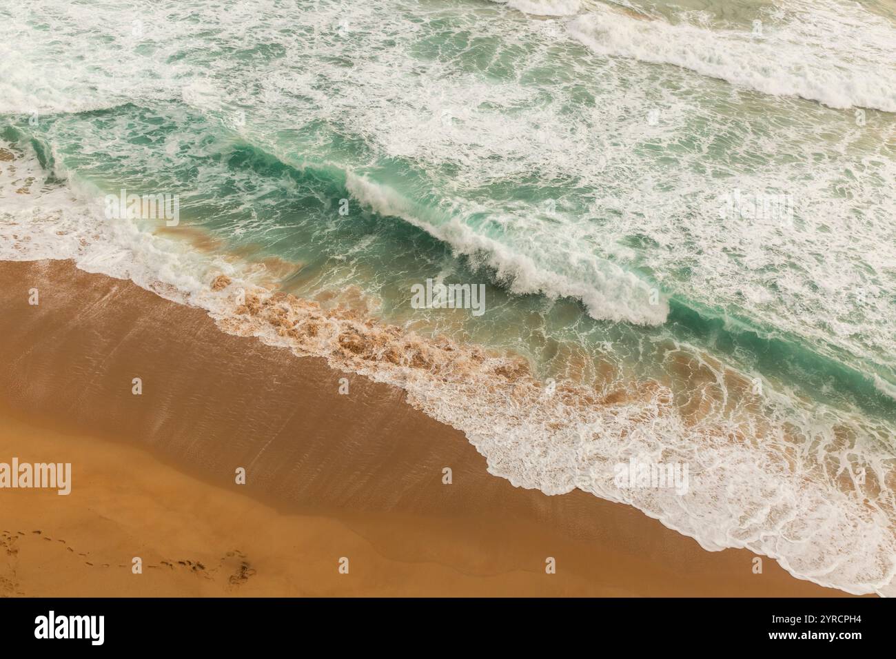 Aerial view of waves crashing onto a sandy beach along the Great Ocean ...