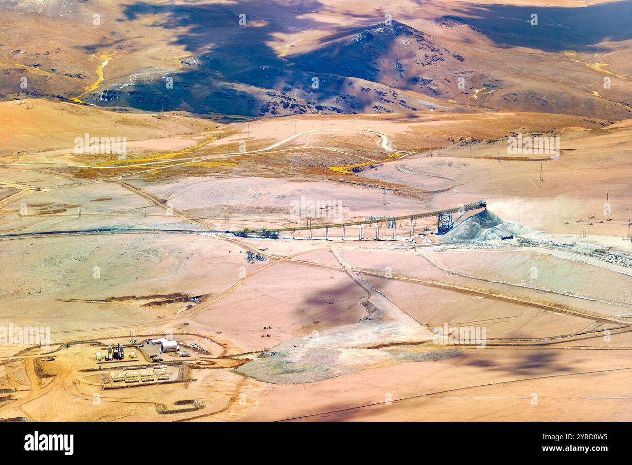 Aerial view of a long conveyor belt and stockpile at a copper mine in ...