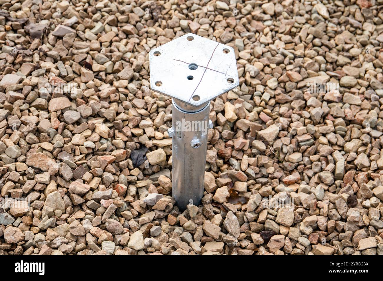 Hot-dip galvanized screw pile screwed into the ground. rubble at the ...