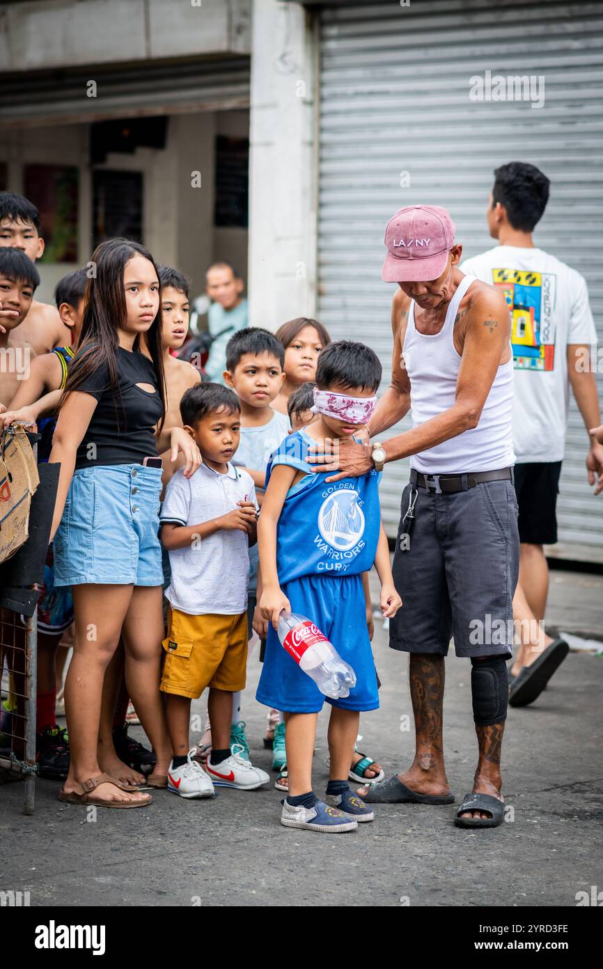 Children play fun street games on the busy streets of the Tondo District of Manila, The ...