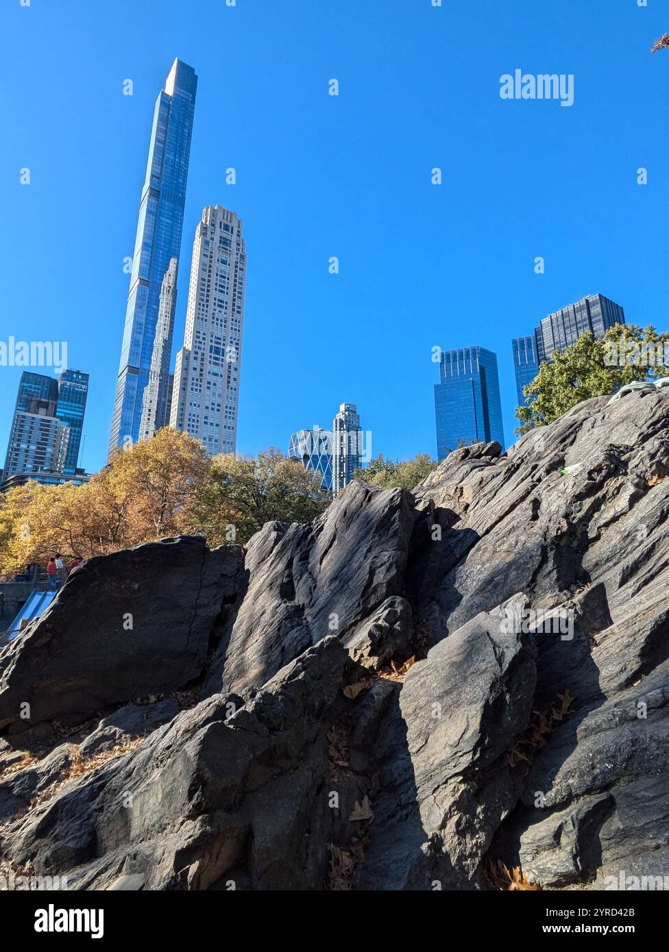 Skyscrapers poking above rocks in central park Stock Photo - Alamy