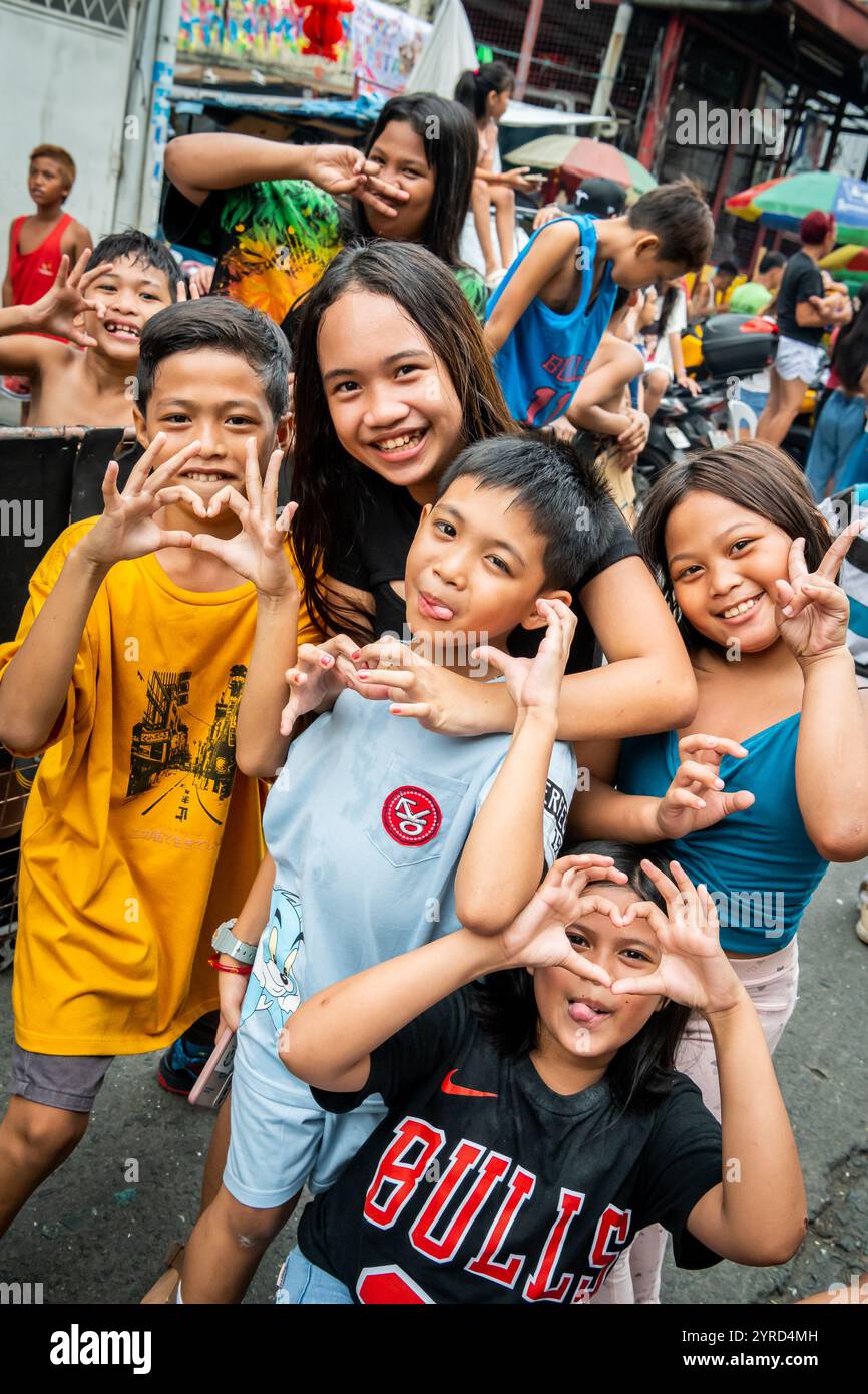 Crowds of cute Filipino children all happily pose and smile for the camera in The Tondo District ...