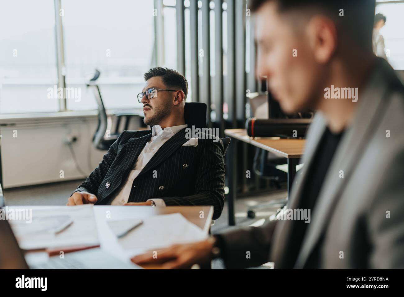 Two diverse business people concentrated on their tasks in a modern ...