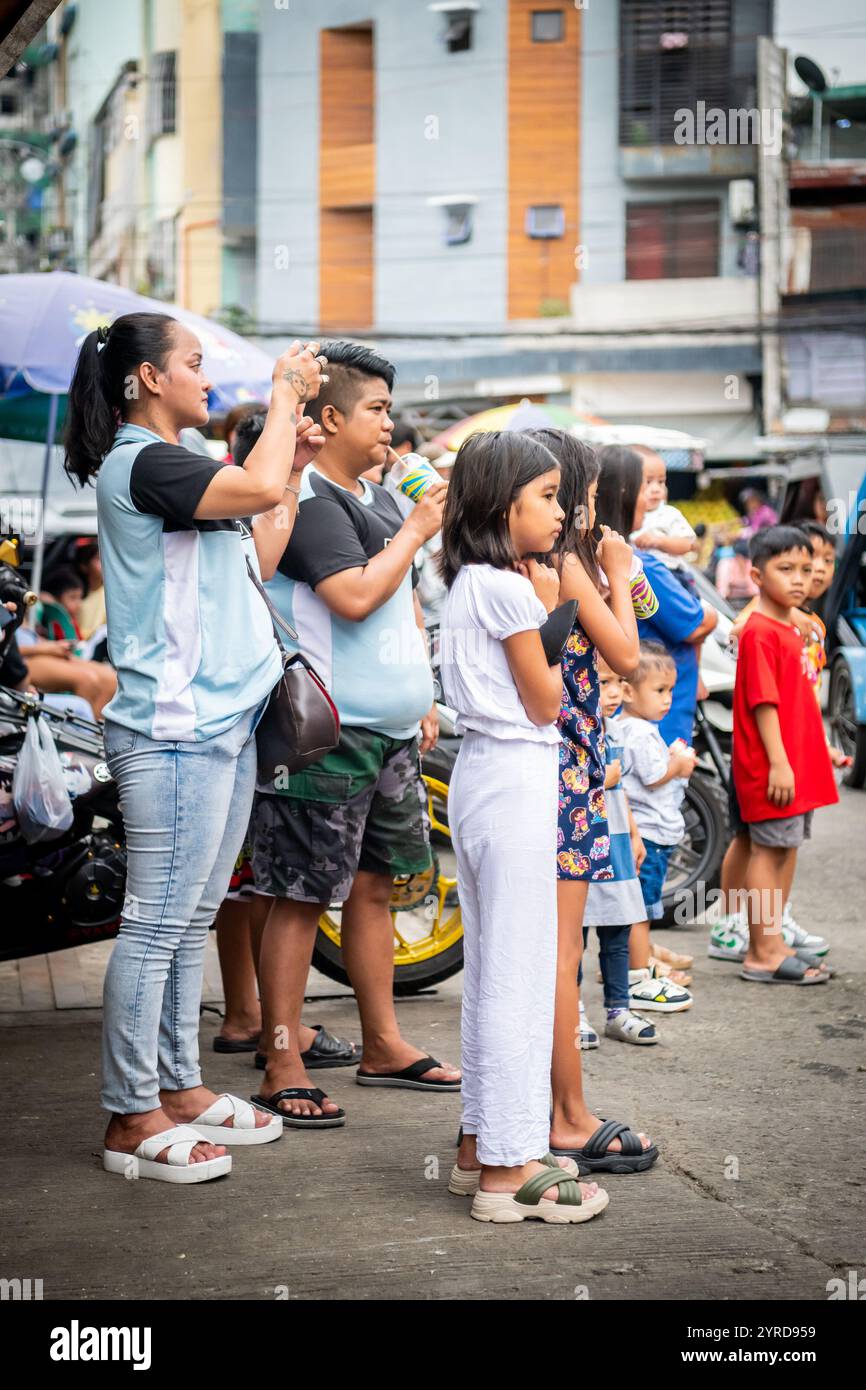 Crowds of Filipino children and parents watch the religious festival ...