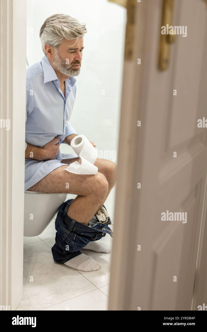 Male sitting toilet suffering hi-res stock photography and images - Alamy