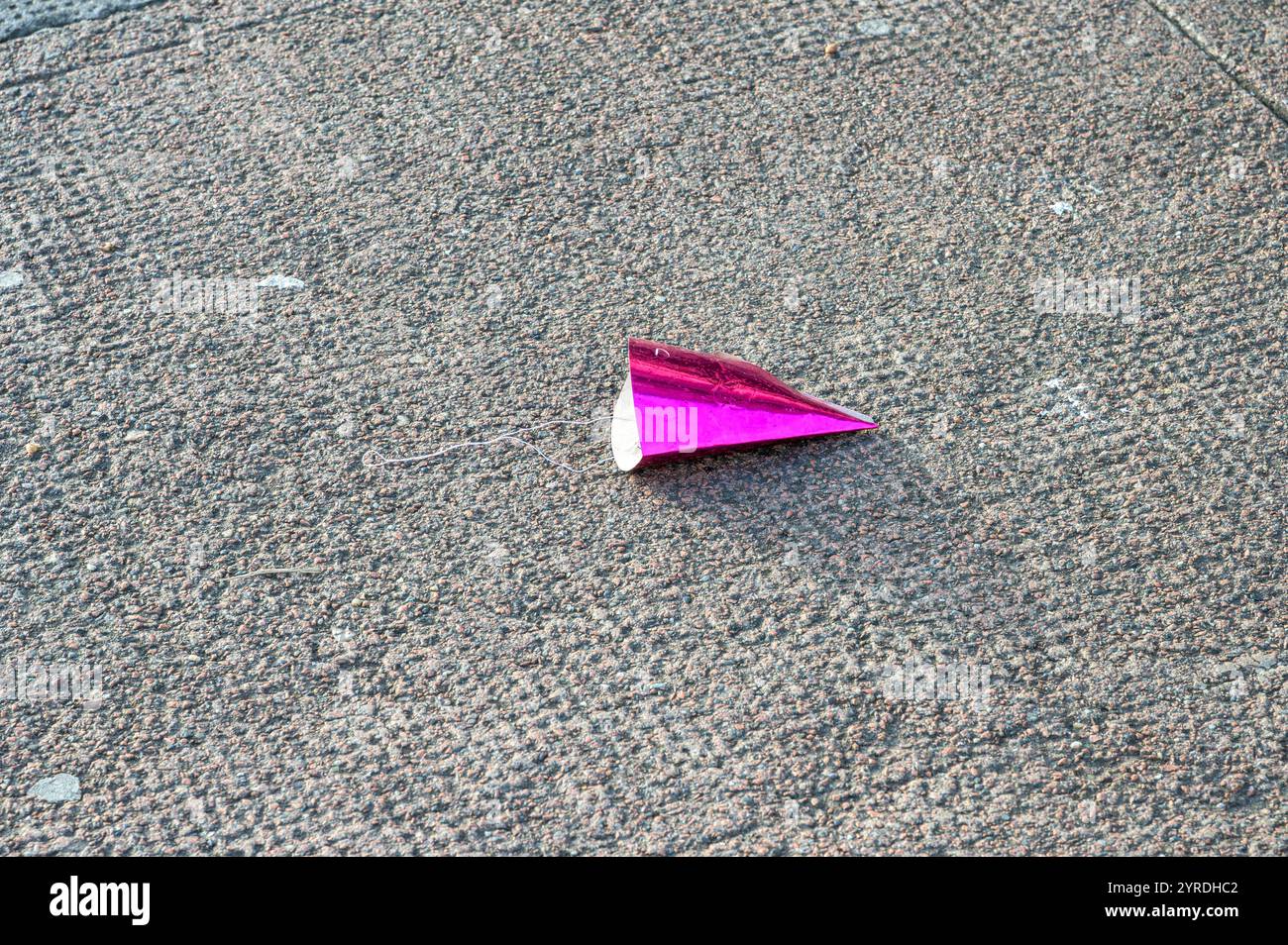 A discarded pink party hat on a pavement Stock Photo - Alamy