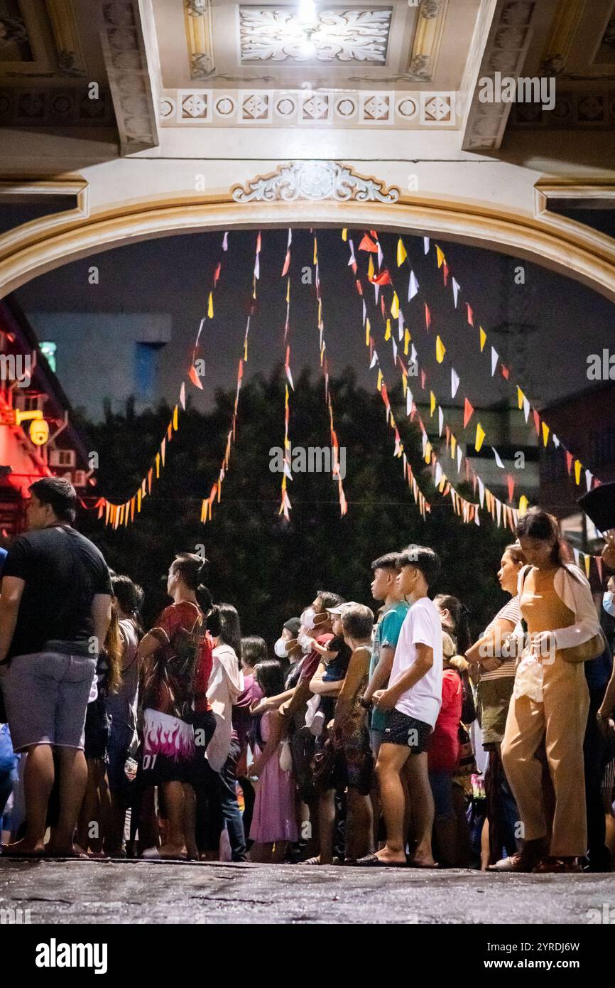 Worshipers line up to enter Santo Nino de Tondo Church in the evening ...