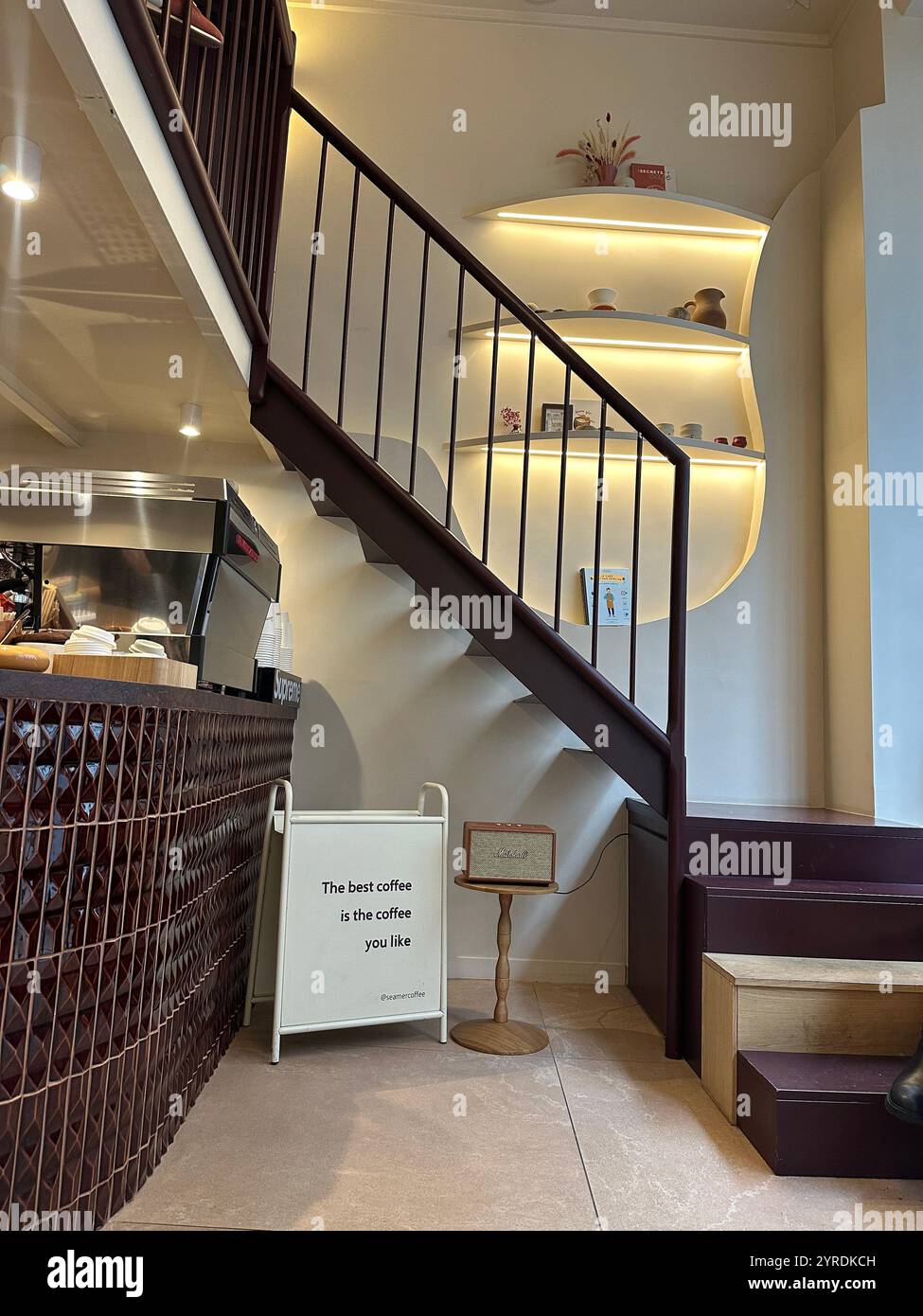 Modern café interior with minimalist staircase, illuminated shelves ...