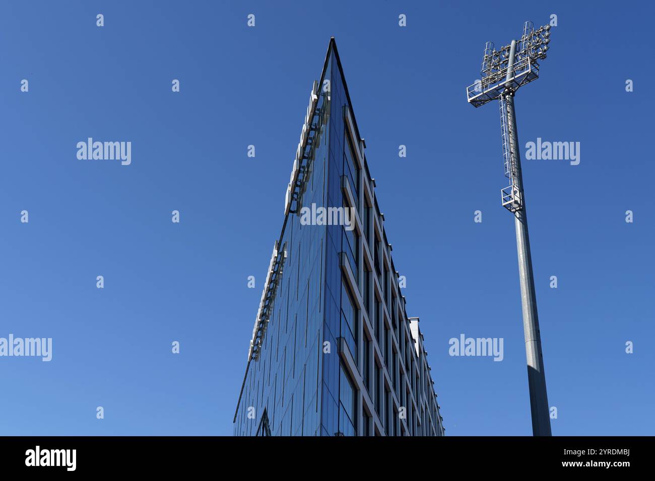 A striking building with a sharp, angular design reaches toward a clear ...