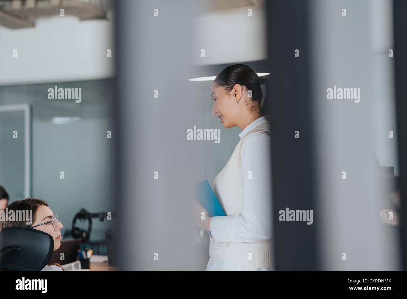 A diverse group of employees engage in a discussion in a contemporary ...