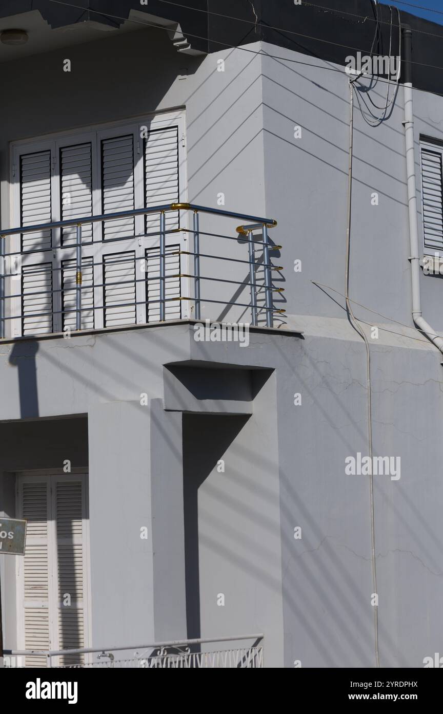 Bright sunlight highlights the unique design of a building balcony ...