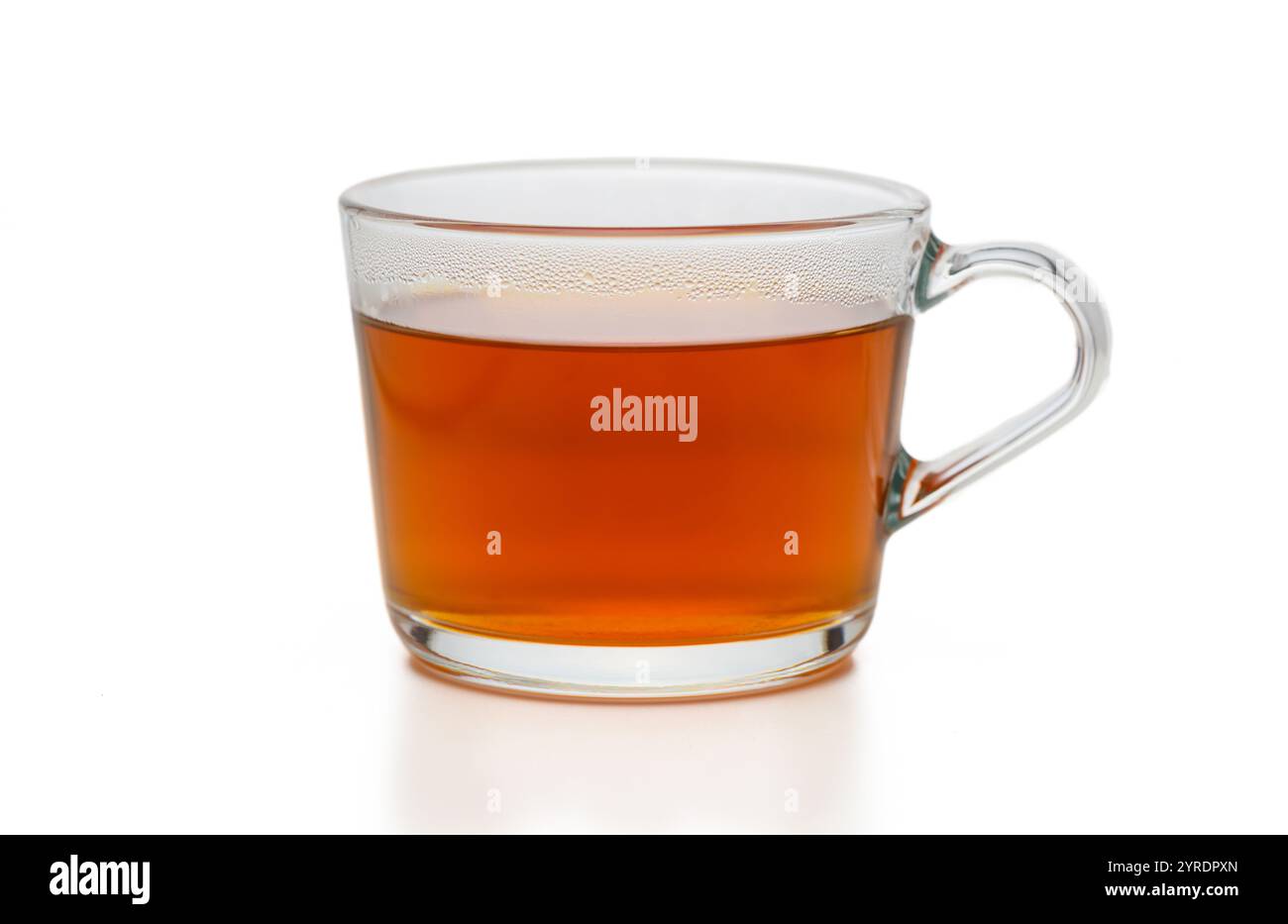 A clear glass cup filled with amber tea evokes a sense of calm, perfect ...
