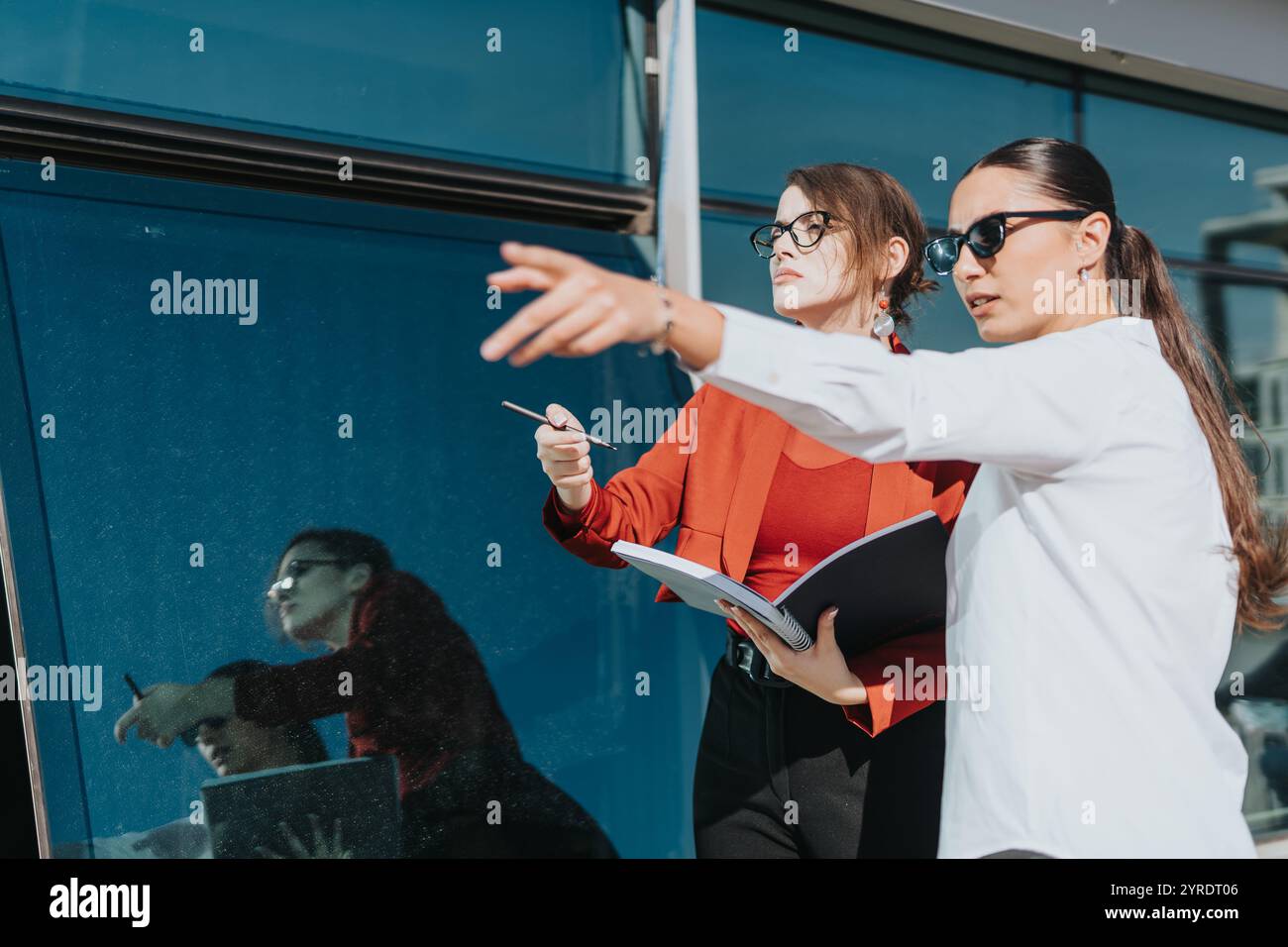 Two professional women are engaged in an animated discussion on a high ...