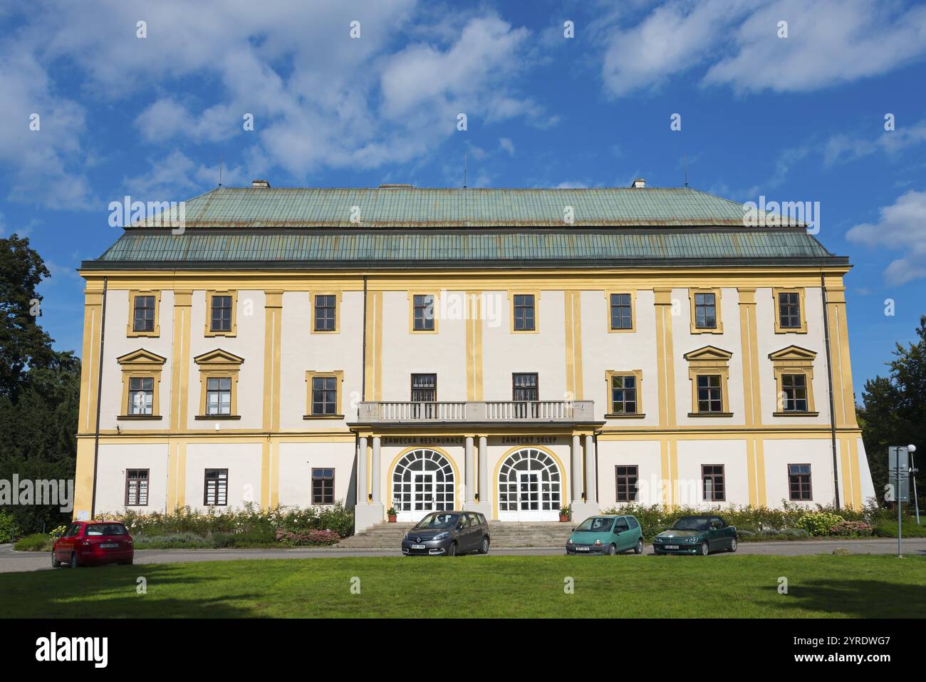 Historic yellow castle with baroque architecture, surrounded by lawns ...