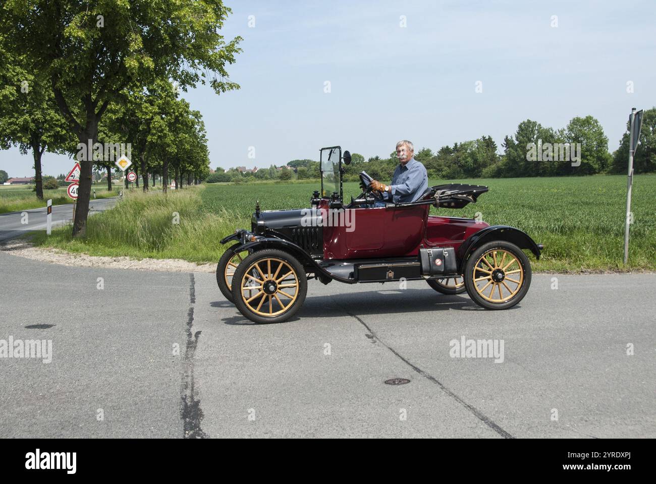 Man driving a classic Ford vintage car on an open country road, Ford T ...