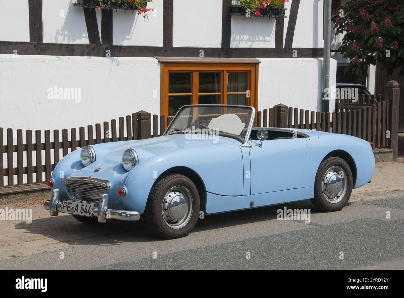 Blue vintage convertible parked in front of a traditional half-timbered ...