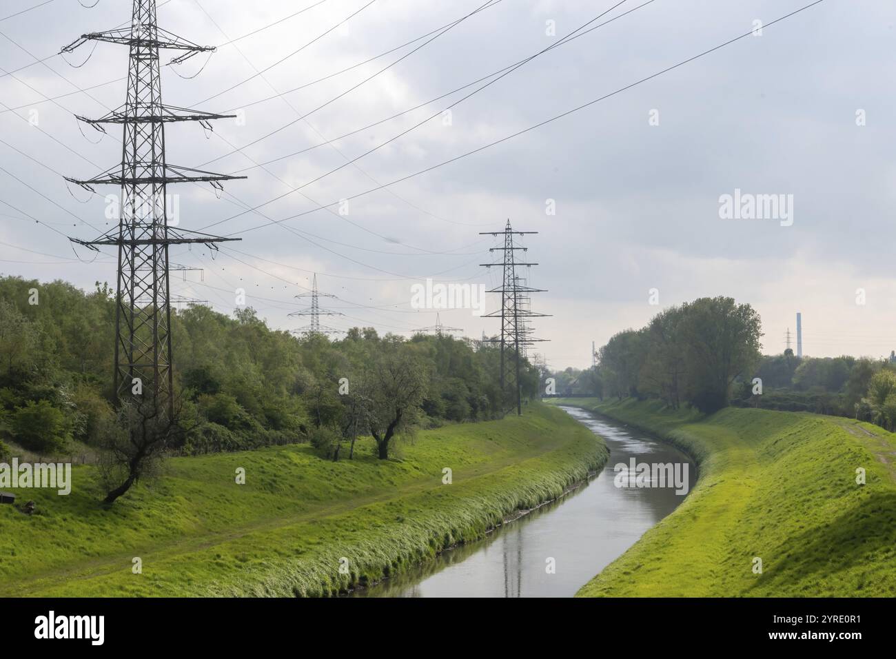Electric pylons with canal in the landscape Stock Photo - Alamy